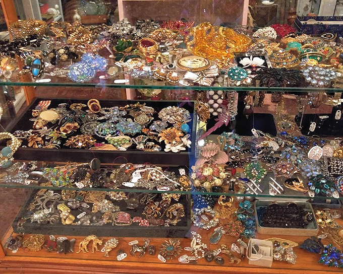 Vintage brooches spread like butterfly specimens, each one a tiny time capsule of fashion history and craftsmanship.