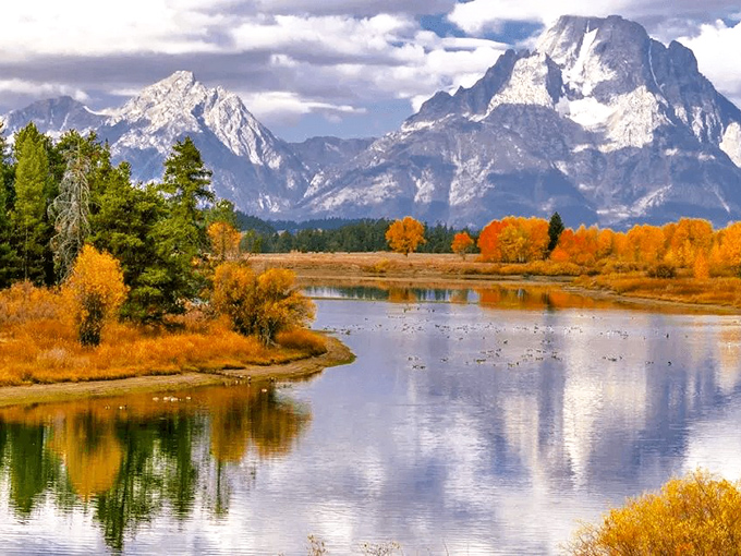 Fall paints Wyoming's wilderness in impossible golds and oranges, creating mirror images on water so still you can almost hear the silence.