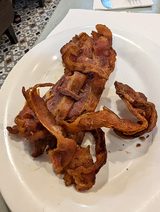 The humble omelet, executed with precision, sits beside home fries that have achieved that mythical balance of crispy exterior and tender interior.