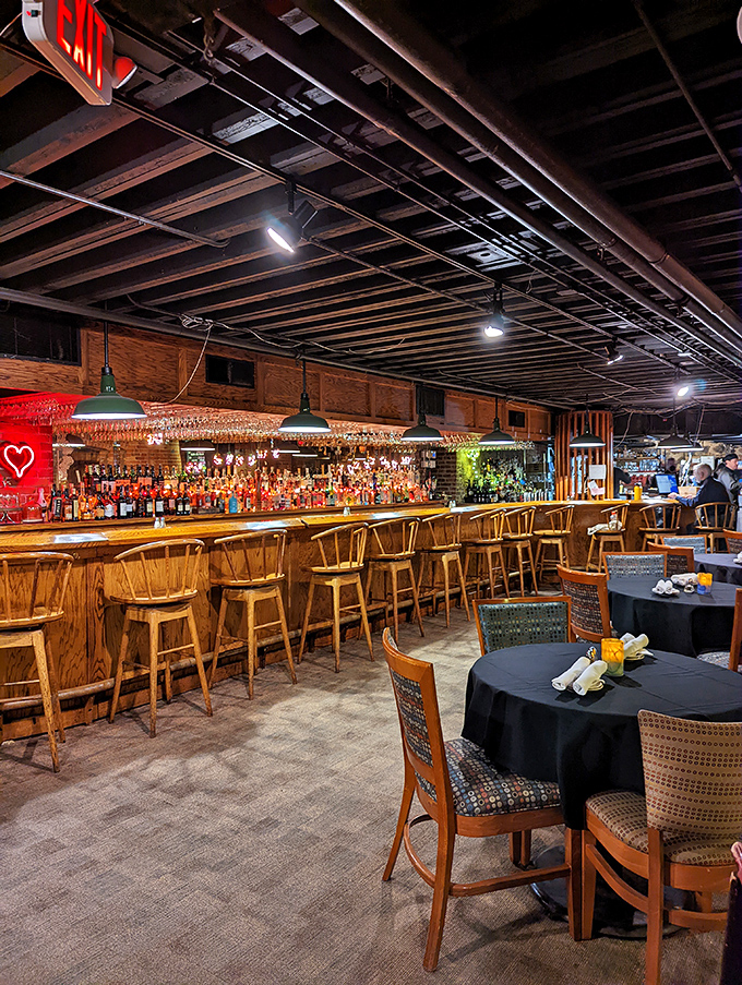 The bar stretches invitingly beneath exposed beams, promising libations that complement the culinary journey ahead.
