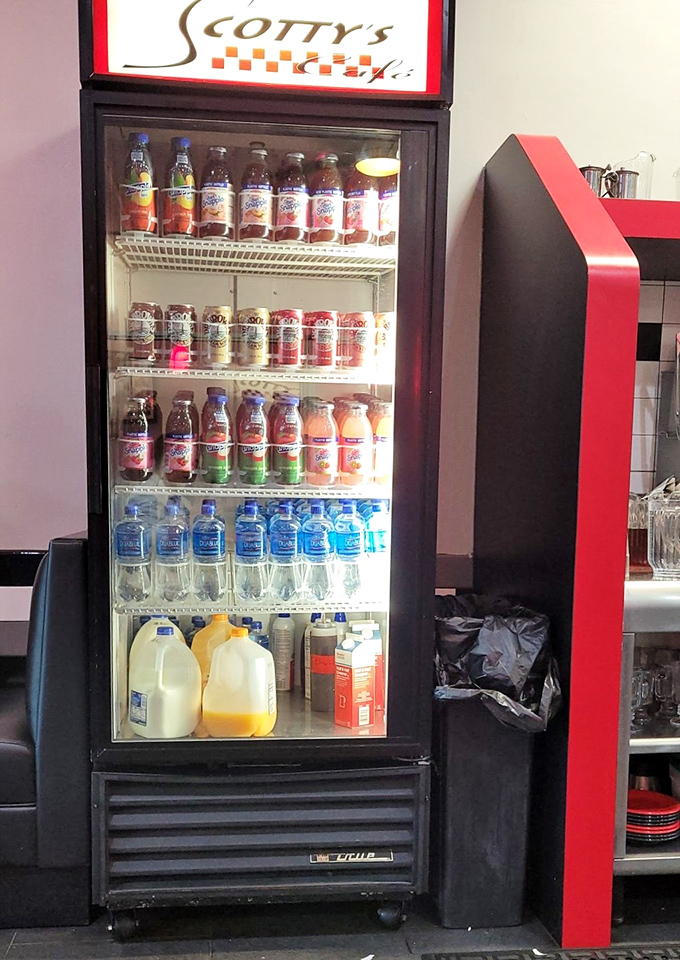 The beverage cooler stands like a colorful sentinel, offering hydration options from milk to every shade of Snapple imaginable.