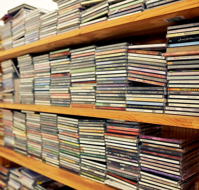 Musical memories stacked like time capsules&mdash;each CD spine representing someone's road trip soundtrack or teenage bedroom dance party.