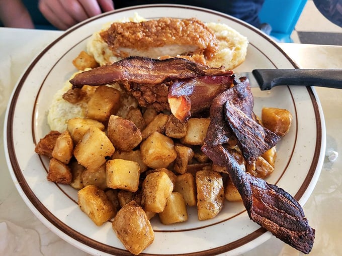 Breakfast of champions! Crispy home fries, perfectly cooked bacon, and what appears to be chicken-fried steak with eggs &ndash; the kind of morning fuel that makes alarm clocks worthwhile.