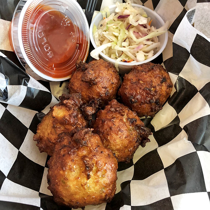 Conch fritters golden-fried to perfection, with slaw and sauce standing by. These crunchy spheres of joy are Florida's answer to donut holes.