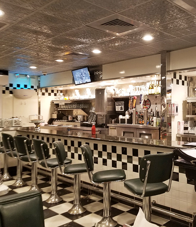 The counter seating offers front-row tickets to the culinary show, where coffee cups are always full and breakfast sizzles with theatrical flair.