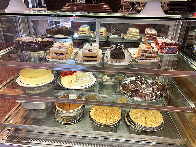 The dessert case—a glass museum of temptation where willpower goes to die and "I'll just have coffee" turns into "and a slice of that chocolate cake."