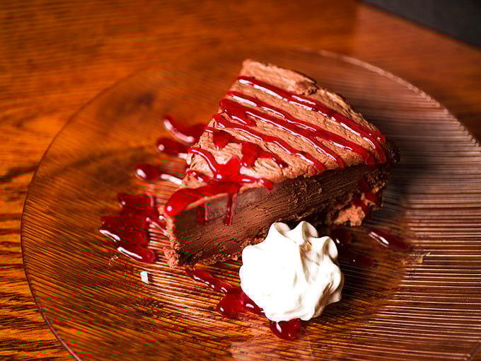 A chocolate dessert so decadent it should come with a warning label. That raspberry sauce isn't just garnish&mdash;it's the perfect sweet-tart counterpoint.