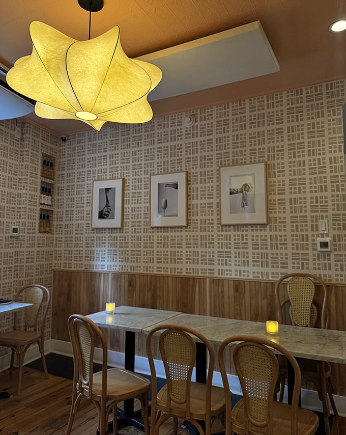 Warm wood paneling meets geometric wallpaper in this dining space that feels both modern and timeless. That star-shaped pendant light adds just the right touch.