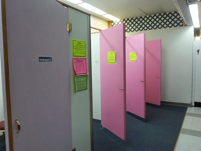 Pink fitting room doors stand like sentinels guarding the moment of truth in every thrifter's journey: "Will it fit?"