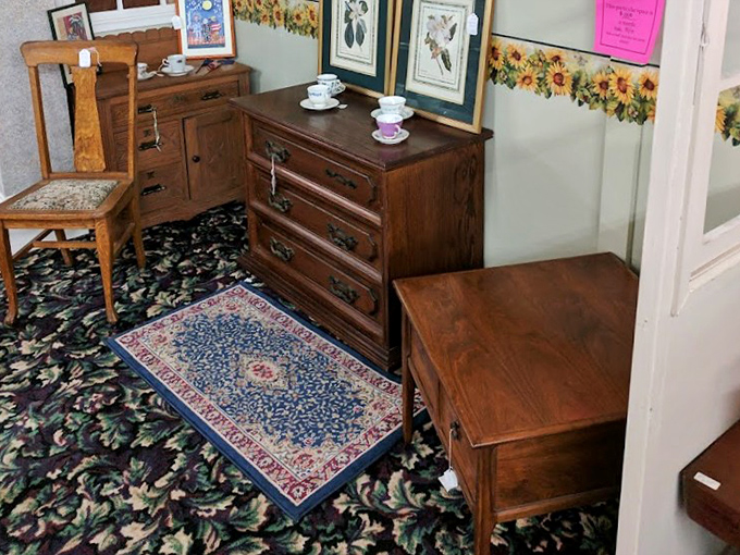 A furniture vignette that could be straight from your great-aunt's house, right down to the floral wallpaper border and miniature teacups.