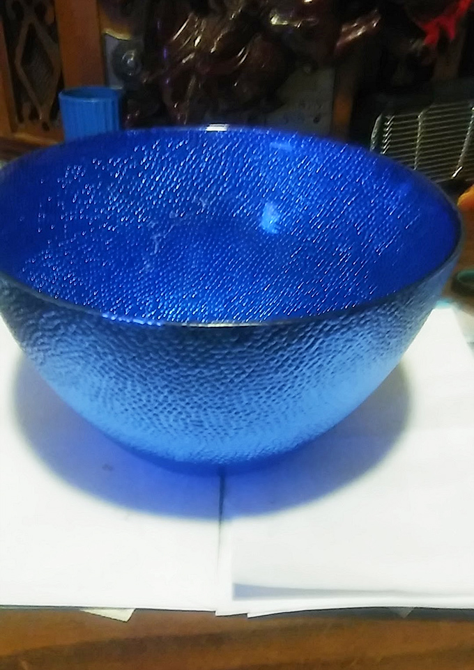 This shimmering cobalt bowl catches light like a sapphire sea, waiting to become the centerpiece of someone's dining table.
