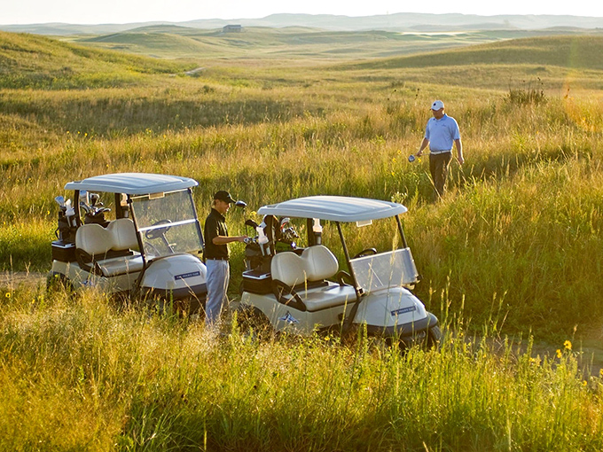 Golf carts navigate the golden prairie grasses, proving that even recreation in Valentine maintains a respectful relationship with the landscape.