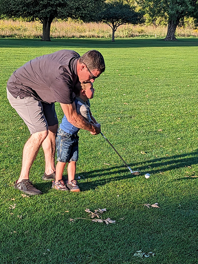 Golf lessons across generations—where patience is taught, frustration is inevitable, and memories are made between swings and misses.