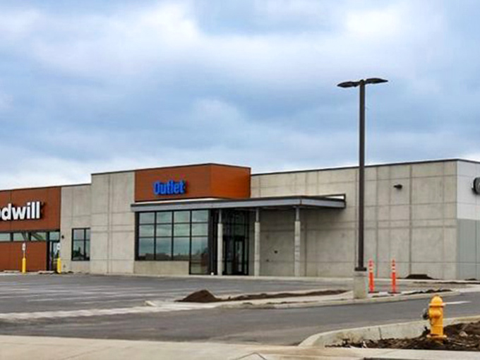 The blue "Outlet" sign beckons from afar, a siren call to those who understand that one person's castoffs become another's treasures.