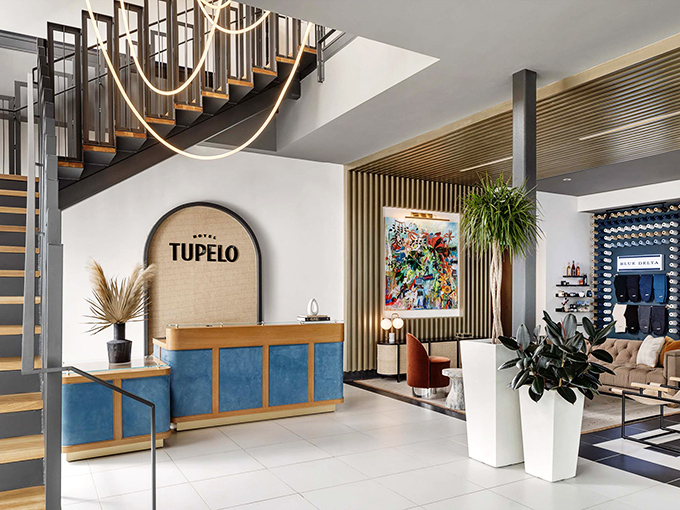Hotel Tupelo's lobby blends mid-century modern with Southern hospitality. That staircase isn't just functional&mdash;it's making an entrance every time you descend it.