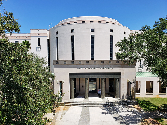 The stately courthouse stands as architectural proof that even legal proceedings look better with palm trees.