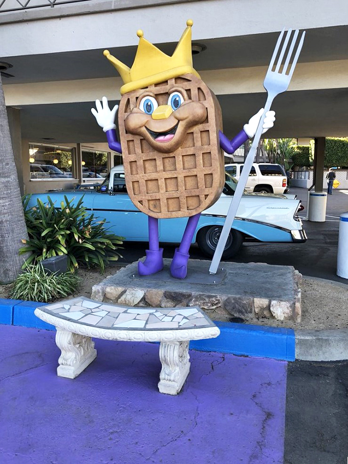 Meet Sir Wafflelot, the crowned breakfast monarch who stands guard outside, fork in hand, ready to welcome hungry subjects.