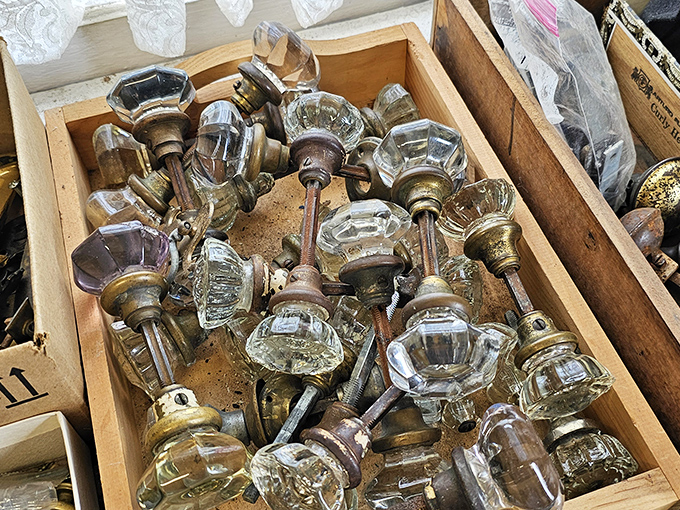 Crystal doorknobs catch the light in their wooden crate, each one a portal to history. Imagine the homes they've graced and the hands that have turned them.