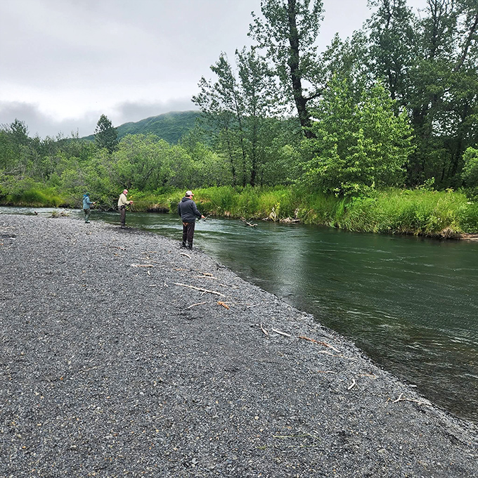 Three fishermen stand patiently along the riverbank, participating in Alaska's version of meditation&mdash;waiting for salmon with breathtaking scenery as a bonus.