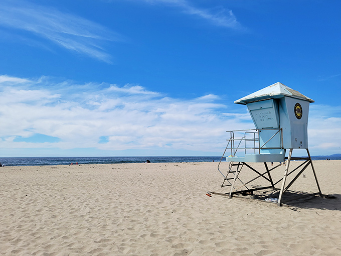 The lifeguard tower stands like a coastal lighthouse, a reassuring presence for those testing their relationship with the Pacific.