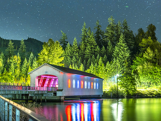 Night transforms the bridge into something magical—like a wooden spaceship ready for takeoff, its colorful lights reflecting in the water below like a dream sequence.
