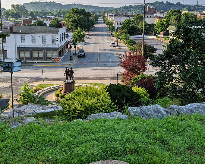 Main Street stretches toward the horizon, its statue standing guard over a town where American literature found its authentic voice.