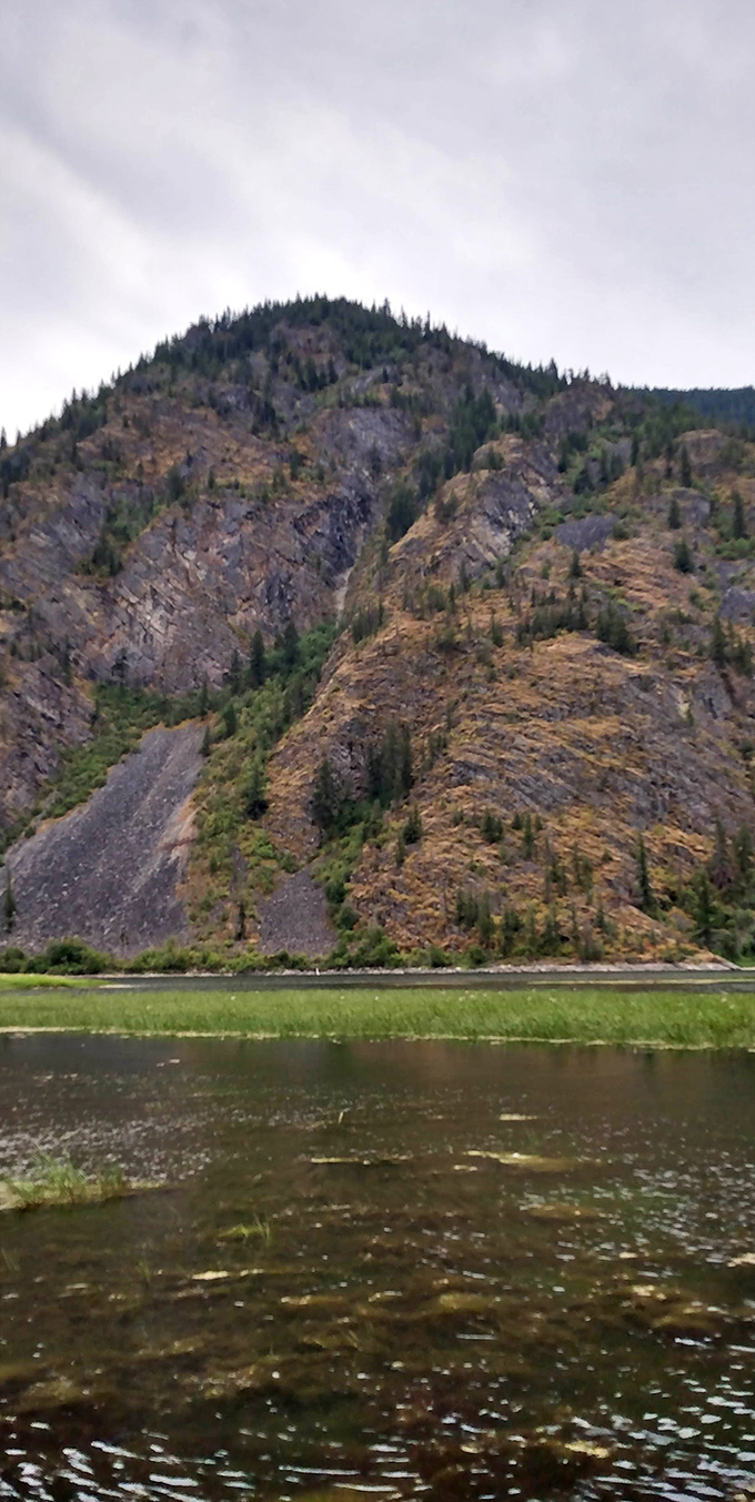 Geological drama on display: These stratified cliffs tell Earth's autobiography one layer at a time, with the river as faithful biographer.