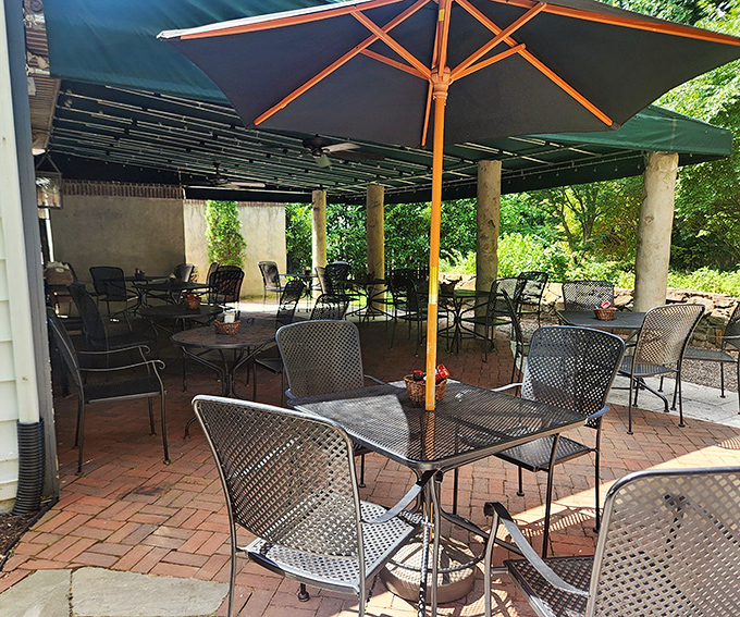 The outdoor seating area offers a sanctuary of brick and shade, where summer evenings stretch lazily into night under string lights and umbrellas.