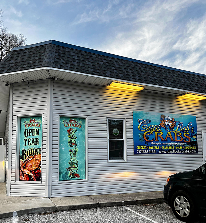 Simple white siding adorned with vibrant signage announces this seafood haven to hungry travelers, promising coastal cuisine worth the journey here.