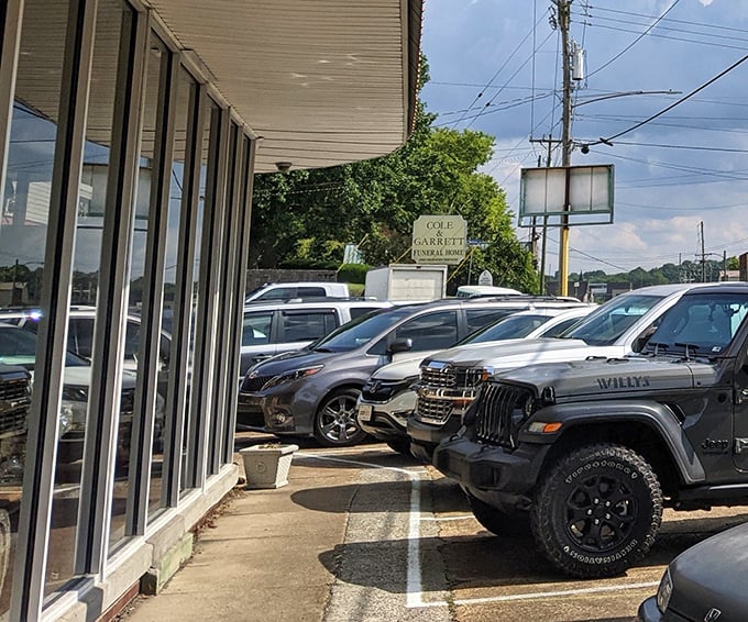 The parking lot tells its own story: modern vehicles waiting patiently while their owners hunt for pieces of the past.