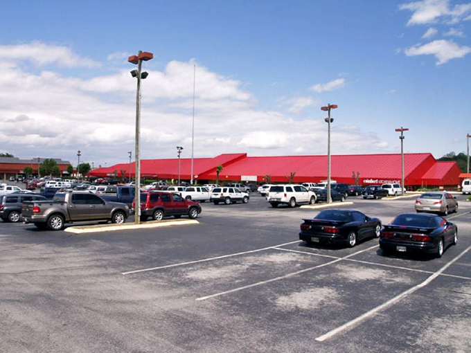 Parking paradise stretches to the horizon. The sea of asphalt promises adventure within those red-roofed buildings of bargain bliss.