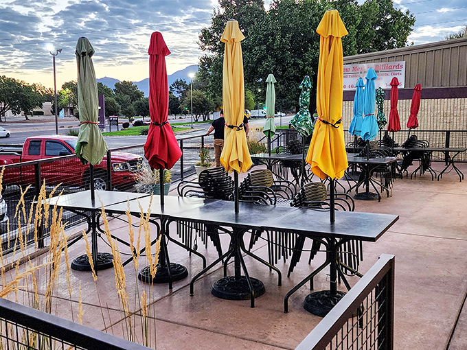 Colorful umbrellas stand ready for outdoor dining with mountain views. Because green chile tastes even better with fresh air.