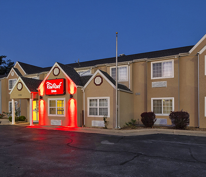 The Red Roof Inn's glowing entrance serves as Springfield's lighthouse for weary travelers, beckoning with the promise of clean sheets and cable TV.