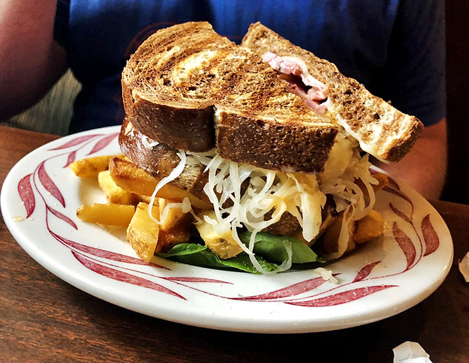 This isn't just a sandwich; it's a skyscraper of flavor where corned beef, sauerkraut, and melted cheese create the perfect architectural balance.