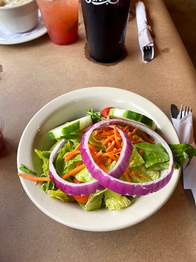 Even the garden salad gets special treatment, with vibrant purple onion rings framing fresh greens&mdash;a colorful prelude to seafood indulgence.