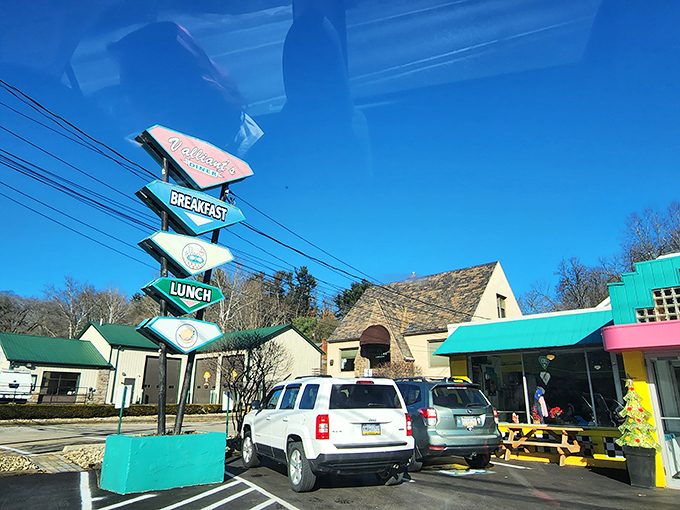 The vintage roadside sign serves as a beacon for hungry travelers. Each arrow points toward the promise of comfort food that delivers on decades of expectations.