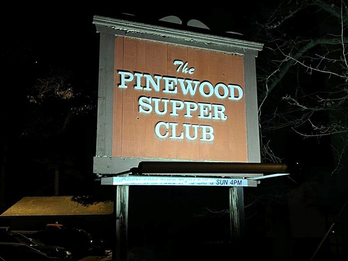 As darkness falls, the illuminated sign becomes a beacon for hungry travelers seeking refuge from chain restaurant mediocrity.