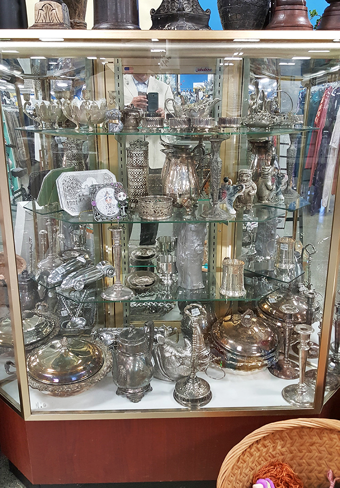 Silver treasures behind glass&mdash;because someone else's wedding gifts deserve a second chance at being appreciated.