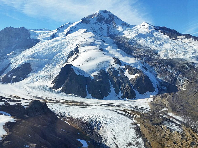 Glaciers carve their slow masterpieces across mountain faces, a reminder that Alaska operates on geological time, not human schedules.