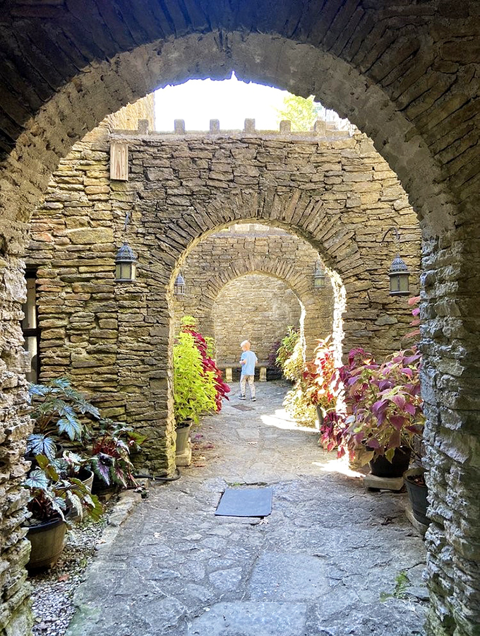 Stone archways create a magical corridor where sunlight plays through multiple openings, nature's own cathedral-like lighting effect.