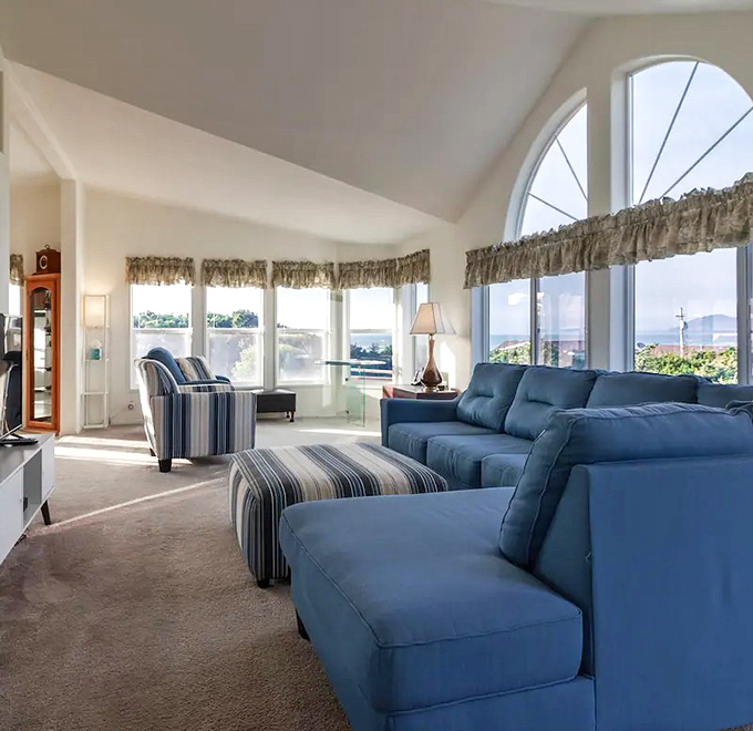 Ocean-view living rooms: where blue furniture mirrors blue horizons, and nobody ever watches the TV when nature's putting on a better show outside.