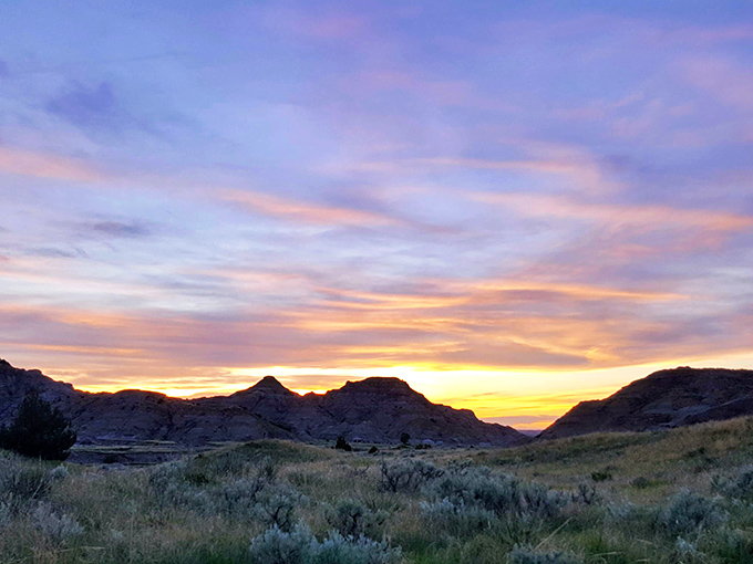 Sunset paints Makoshika's rugged skyline in watercolor hues that would make Bob Ross reach for his happy little brush.