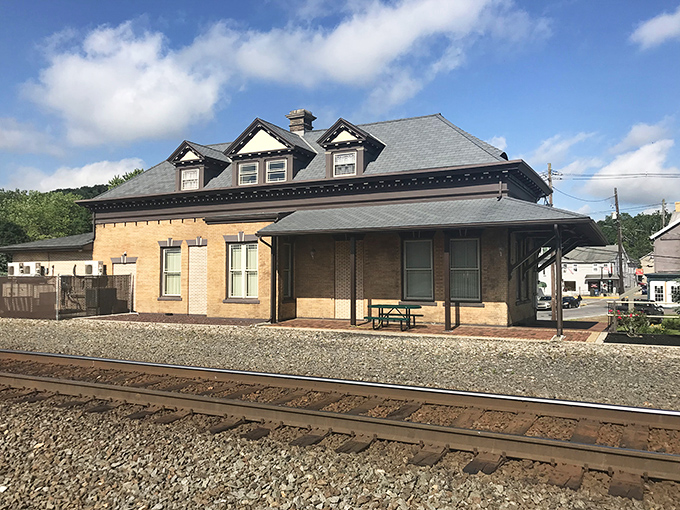 The old train station waits patiently for passengers who will never arrive, its sturdy construction a testament to bygone craftsmanship.