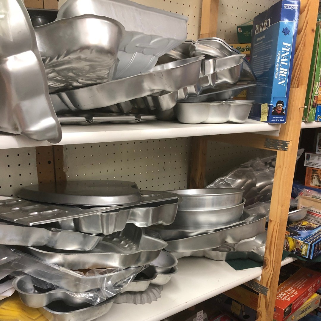 Cake pans that have seen countless birthdays, holidays, and potlucks. Each dent and scratch represents someone's "famous" recipe once served with pride.