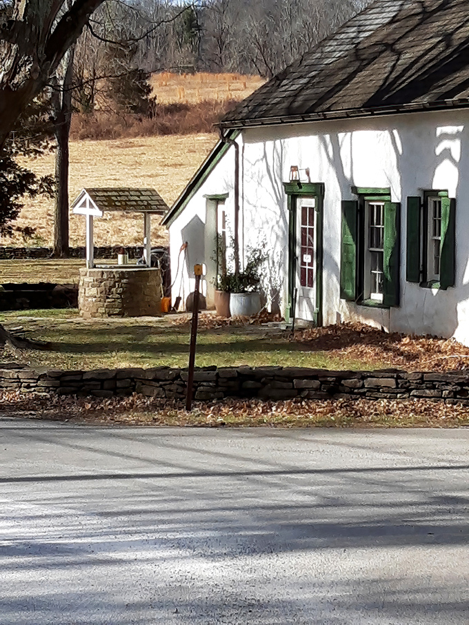 Nearby, this charming stone well house completes the historical landscape, a perfect companion to the bridge.