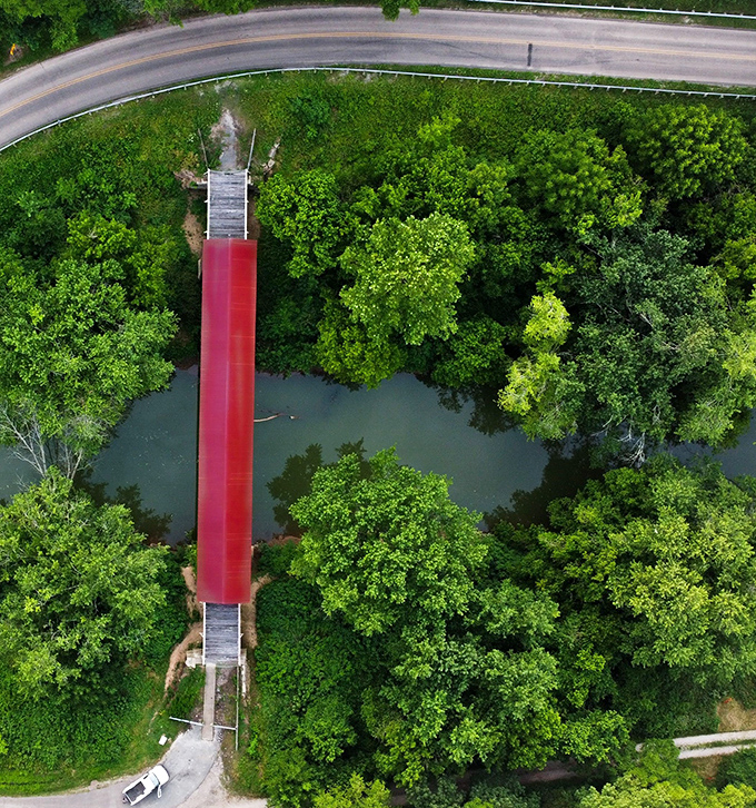 From above, the bridge appears as a bold red brushstroke across a canvas of green—an artist couldn't have composed a more perfect scene.