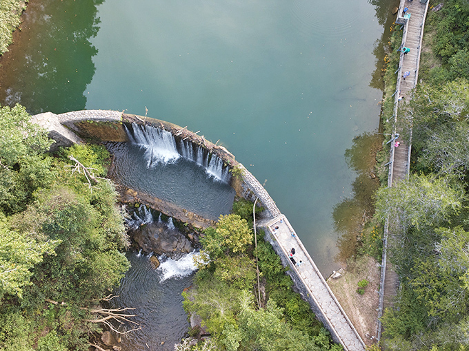 From above, the curved dam reveals itself as an artist's brushstroke across the landscape, blending human ingenuity with natural beauty.