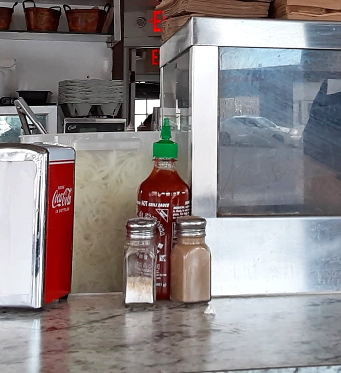 The essentials of American dining&mdash;salt, pepper, and hot sauce standing at attention. These silent heroes enhance every bite without stealing the spotlight.