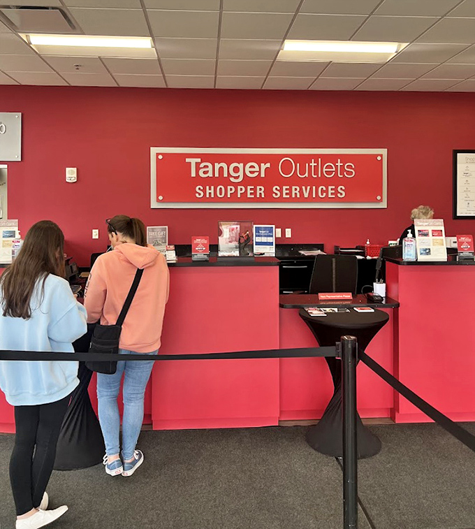 The bright red Shopper Services counter stands ready to assist with questions, purchases, and occasional shopping-induced existential crises.