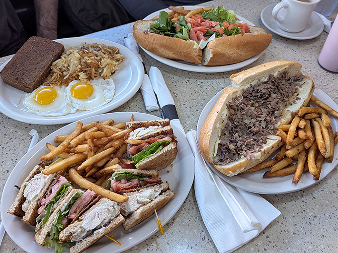 A spread of breakfast plates and towering sandwiches that could feed a small army or one very determined breakfast enthusiast.